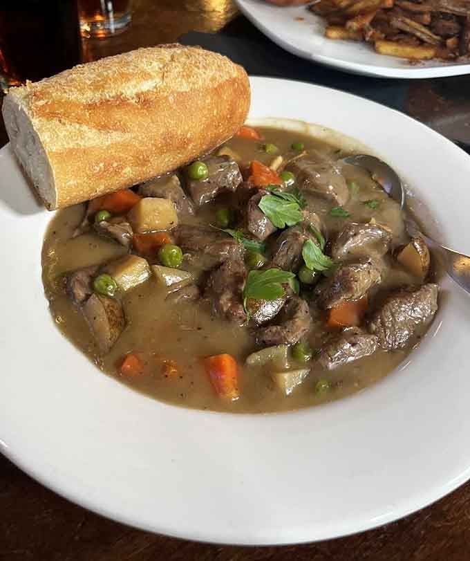 A bowl of classic Irish Lamb Stew with a fresh baguette, warm enough to fix almost anything.