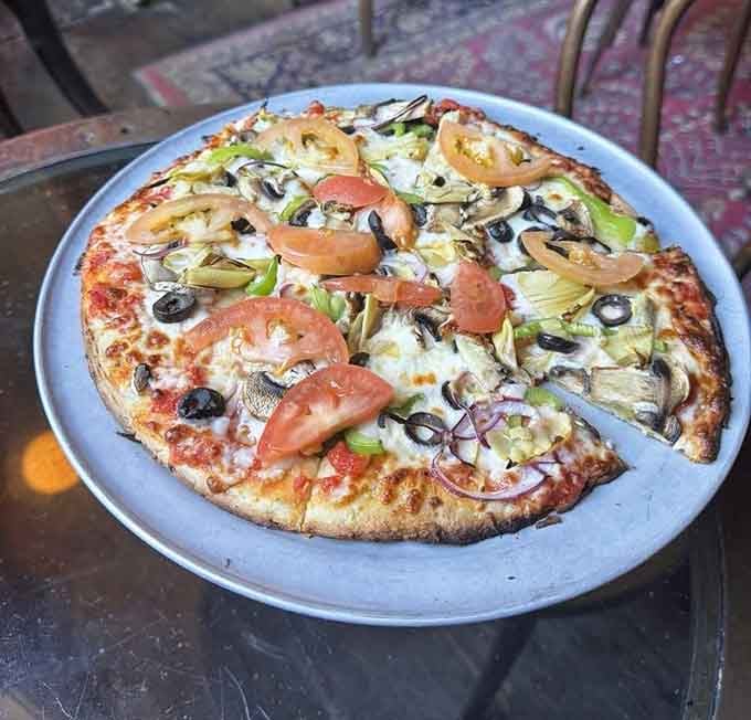Fresh tomato, artichoke hearts, black olives, and mushroom piled high. Proof that vegetables can absolutely hold their own on a pizza.
