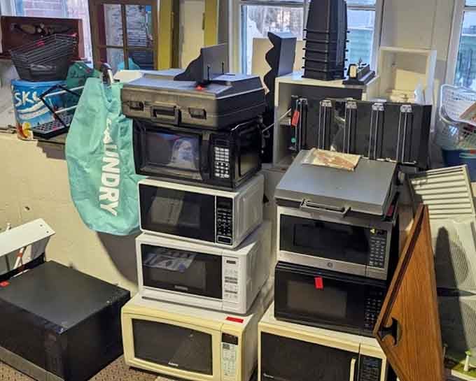 A tower of microwaves stacked like a retro skyscraper, because apparently Connecticut runs on second chances and surplus appliances.