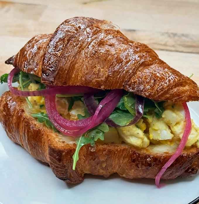 Egg salad gets the gourmet treatment it deserves, nestled in a croissant that could win awards.