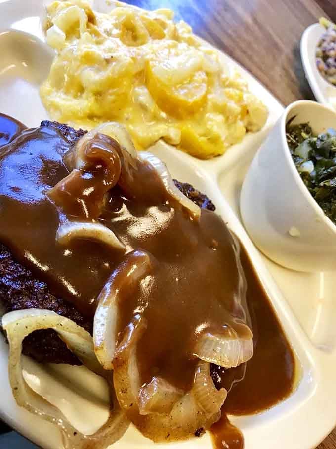 Hamburger steak buried under rich gravy and soft onions, with mac and cheese alongside. Someone in that kitchen genuinely cares about you.