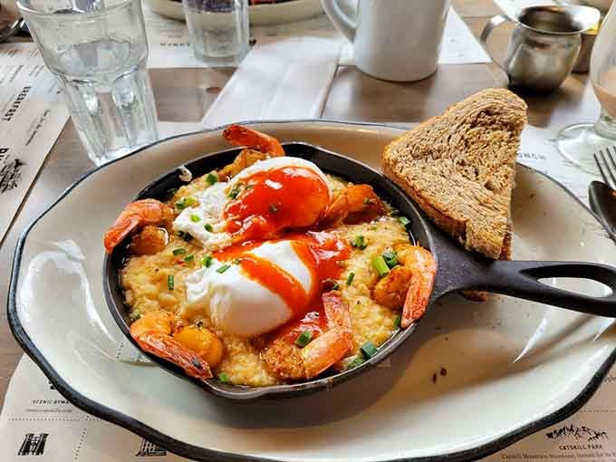 Shrimp and grits in a skillet with poached eggs creates Southern comfort in the heart of New York.