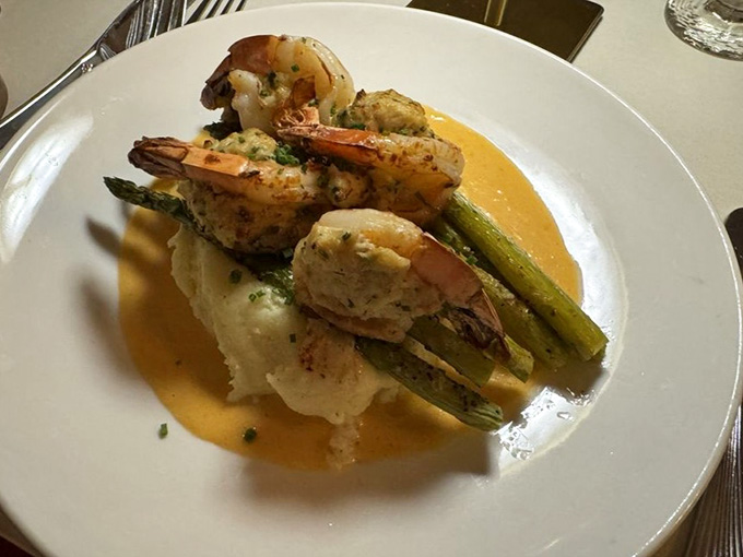 Crab-stuffed shrimp over mashed potatoes in a golden sauce that looks like a standing ovation on a plate.