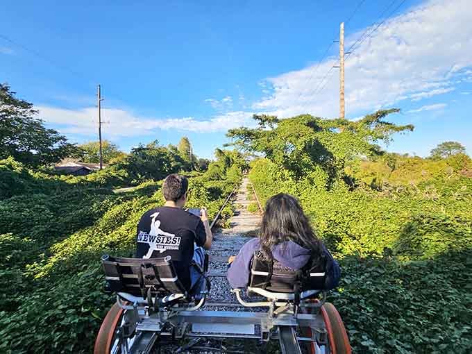Two riders disappear into a lush green corridor, looking like they've found a secret the rest of us missed.