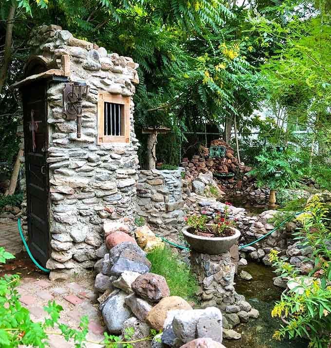 A hand-built stone structure tucked into lush greenery, looking like something straight out of a storybook nobody told you about.