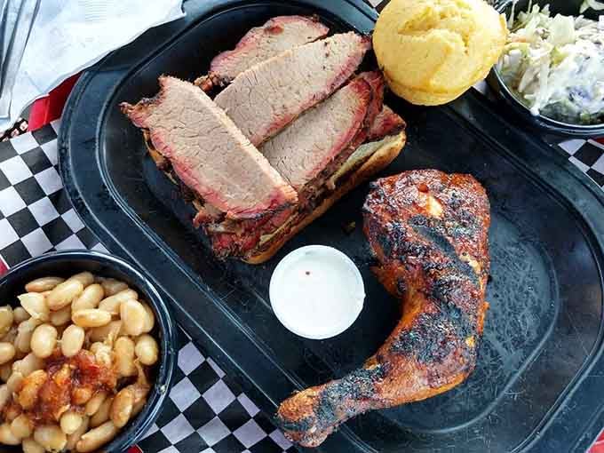 Sliced brisket and smoked chicken sharing a tray, proof that good things love good company.