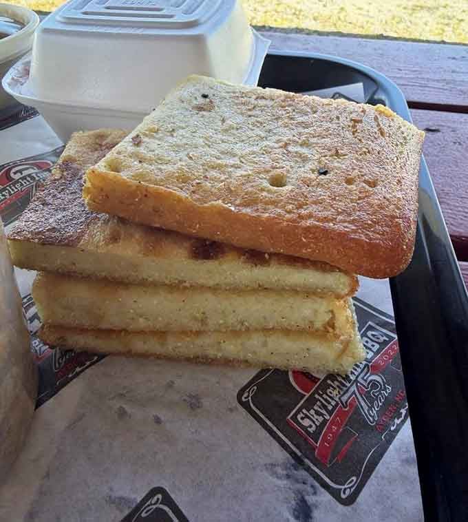 Four thick slices of scratch-made cornbread, crispy outside and dense inside &mdash; honestly, this deserves its own fan club.