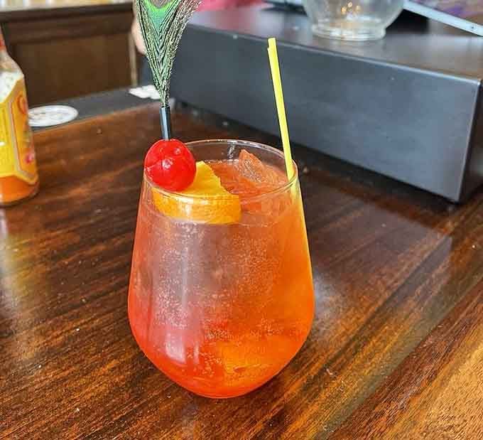 That peacock feather garnish says everything. This cocktail came dressed for the occasion and showed up early.