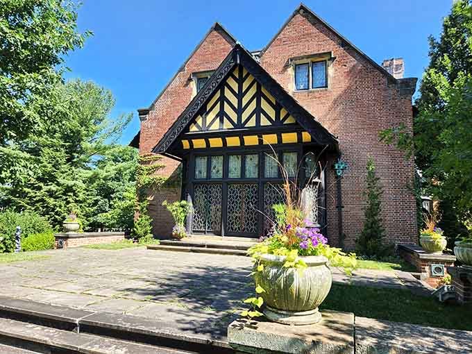 The South Terrace entrance, where the Tudor Revival architecture and summer blooms compete for your attention equally.