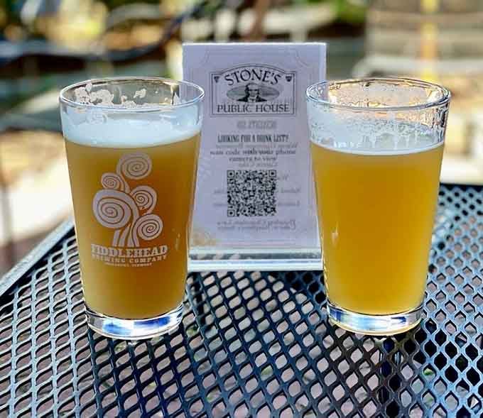 Two golden pints of craft beer sitting beside a Stone's drink menu, because good decisions come in pairs.