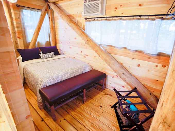A proper bed tucked under the roofline, with trees right outside the window. Sleep well tonight.