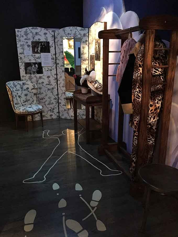 A chalk outline on the floor and a rack of costumes nearby. Theater was never boring here.