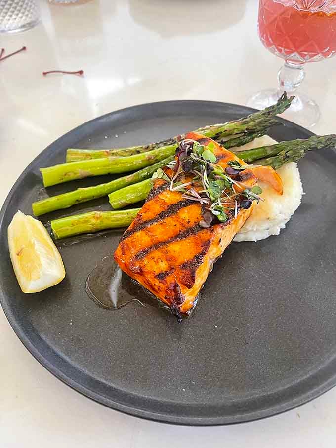 Perfectly charred salmon over a cloud of something creamy, with asparagus standing at attention alongside it.