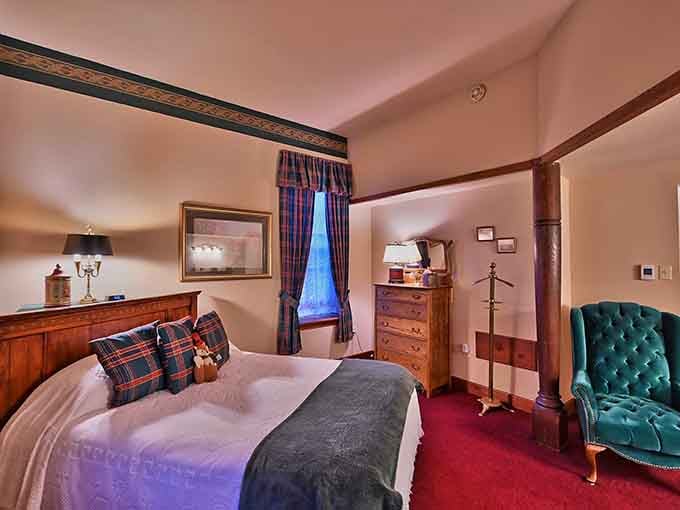 Plaid curtains, a tufted velvet chair, and warm wood tones. This guest room is cozy in the best possible way.