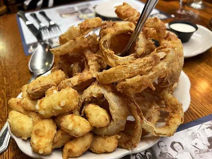 Cheese curds and onion rings piled high, the kind of appetizer that makes you reconsider your entire dinner strategy immediately.