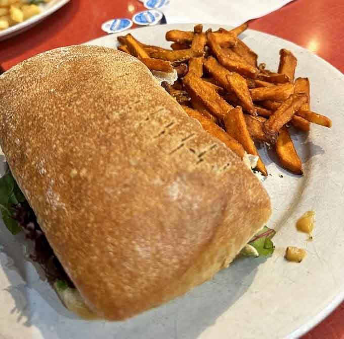 Tucked inside a sturdy roll and paired with sweet potato fries, this sandwich is the kind of lunch you plan your day around.