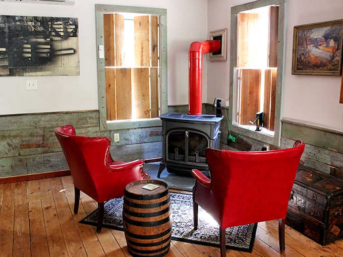Two red chairs, a wood stove, and a barrel for a coffee table. Someone here has excellent taste.