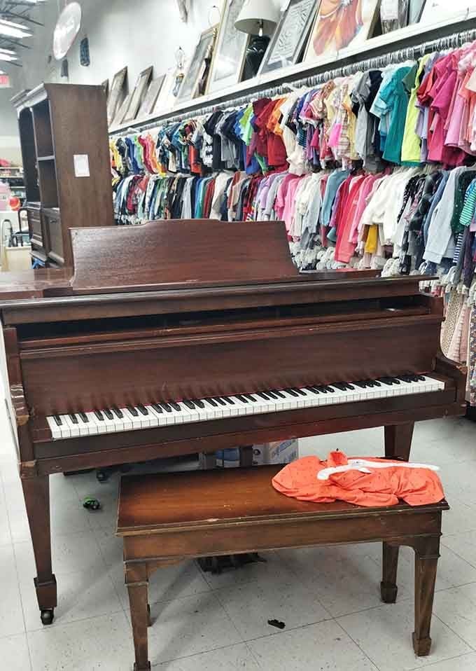 A real upright piano sitting casually among the clothing racks, because why not make shopping musical?