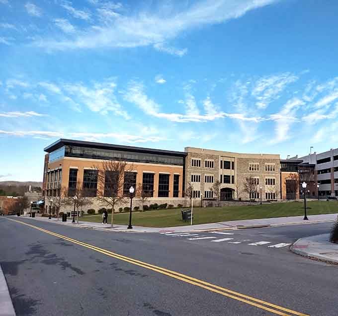 Stroll past these modern, multi-story brick campus buildings overlooking a wide roadway under a beautifully patterned, wispy blue sky.