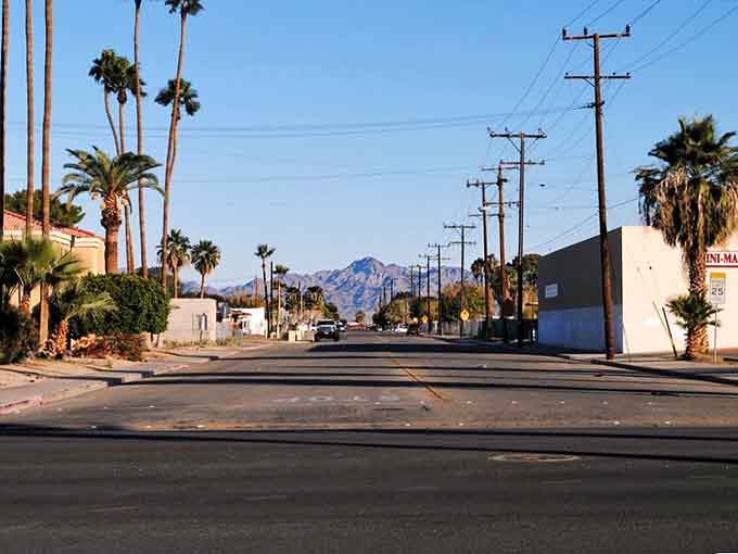 Palm trees line a quiet Blythe street where golden light and mountain silhouettes make every evening feel cinematic.