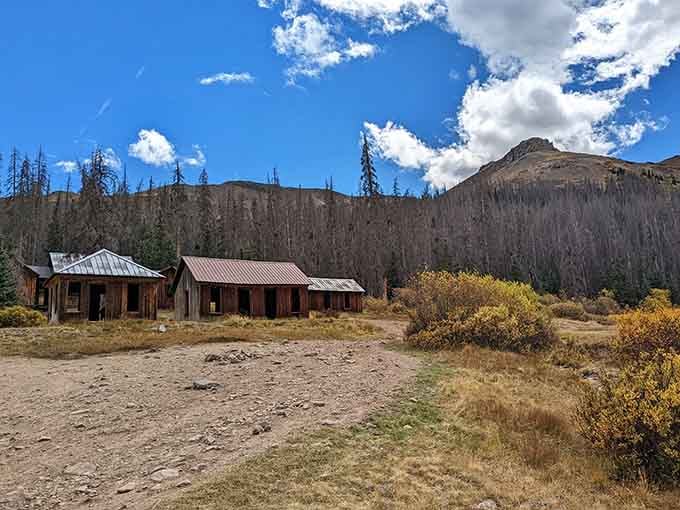 Carson's cluster of rusted-roof buildings sits wide open under a big Colorado sky, surrounded by scrubby brush and pure mountain silence.