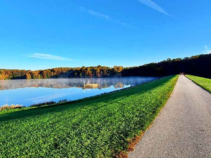 Morning mist drifts across a glassy Centennial Lake, with fall foliage blazing on the far shore like nature showing off.