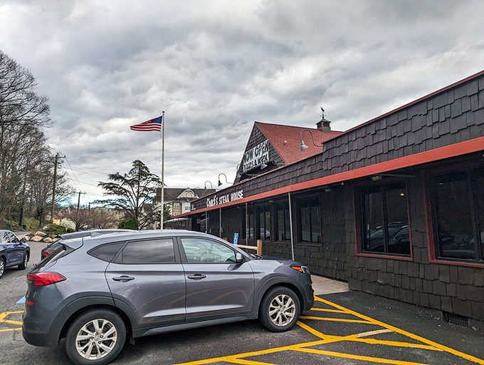 Under a dramatic cloudy sky, Chuck's dark shingle exterior and proudly flying flag radiate classic American steakhouse confidence.