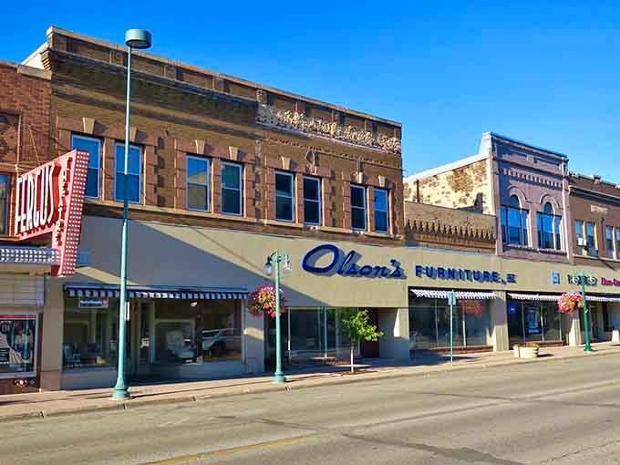 Olson's Furniture sign in cursive script is pure Americana, sitting proudly beneath ornate roofline details that downtown architects simply don't bother with anymore.