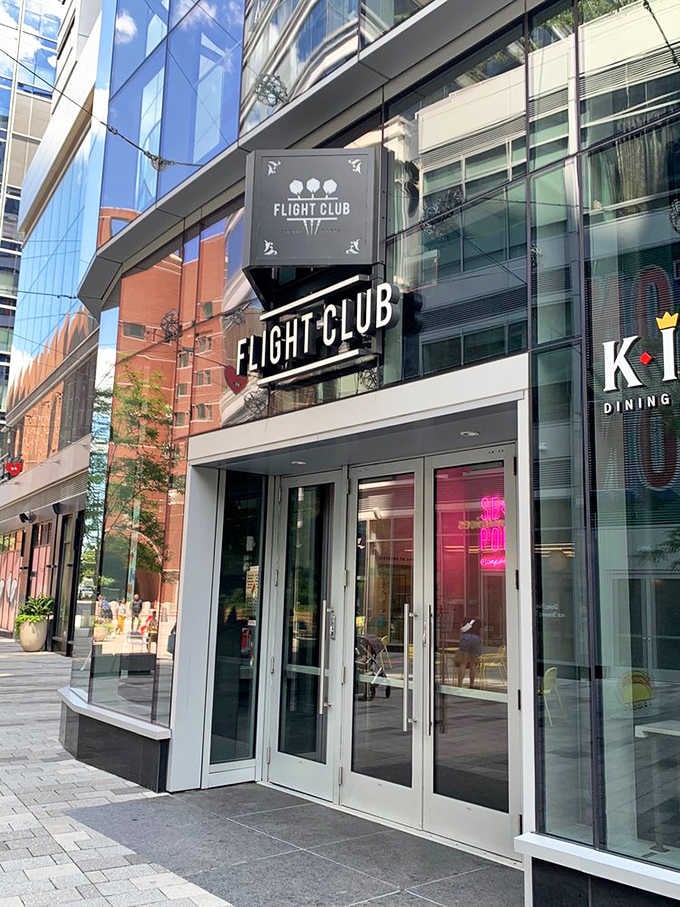 Modern glass and steel frame this sleek entrance where traditional pub games get a sophisticated twenty-first century upgrade.