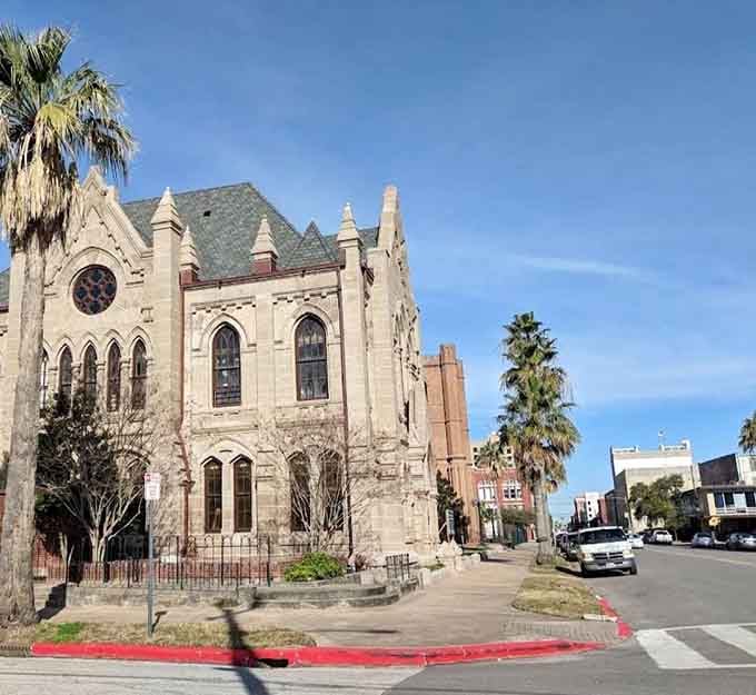 Gothic stone arches and swaying palm trees on a Galveston street corner create a scene that feels gloriously out of time.