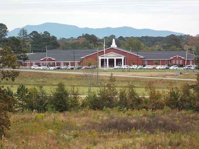 A proud red brick building standing tall with the Appalachian foothills as its breathtaking backdrop.