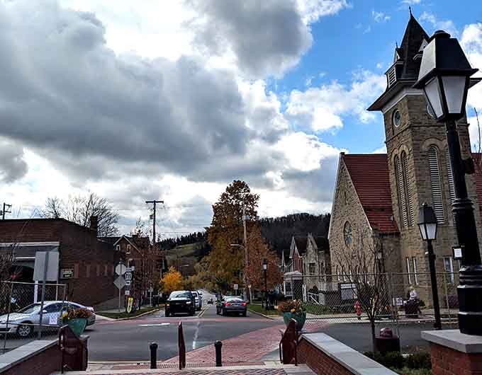Dramatic clouds roll over the stone church tower, adding natural drama to this already picturesque mountain setting.