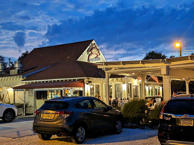 Warm golden lights spill across the parking lot at dusk, making Mud City Crab House look like the coziest destination on the Shore.
