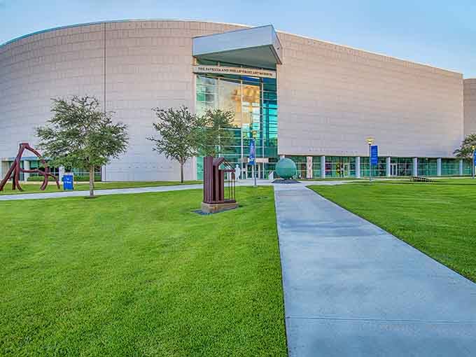 Sculptures dot the sweeping green lawn at golden hour, turning the walk to the Frost's entrance into its own gallery experience.