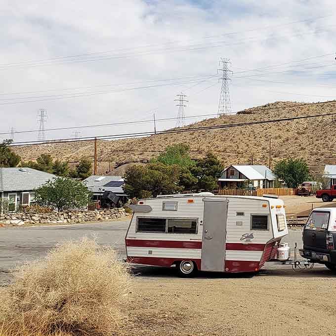 A vintage trailer parked on a dusty street, looking like it rolled straight out of a 1970s road trip.
