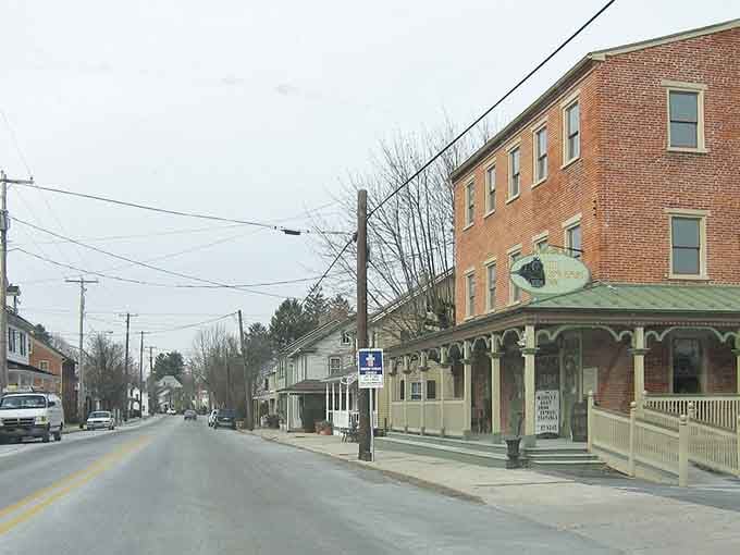 Brick buildings march down this peaceful street, their Victorian details whispering stories of summers past and traditions preserved.