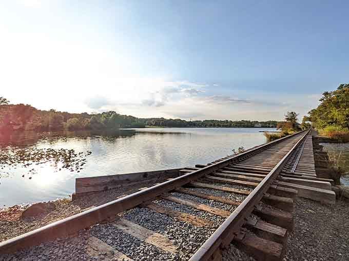 Abandoned railroad tracks beside still water create a hauntingly beautiful reminder of journeys past and present.