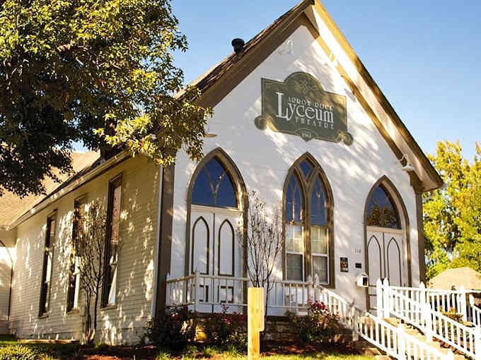 Gothic windows on this converted church now welcome theater lovers instead of Sunday morning congregations.