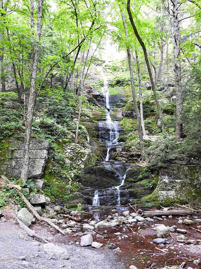Surrounded by a lush green canopy, Buttermilk Falls threads gracefully down ancient rock, patient and powerful all at once.