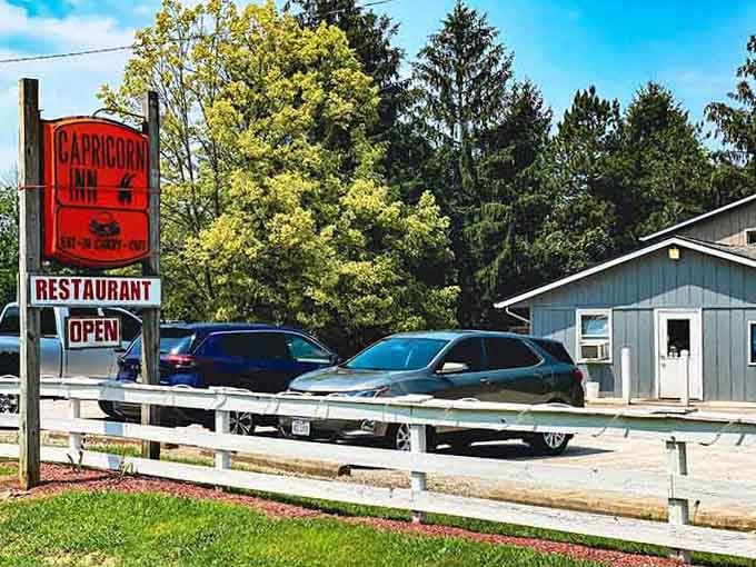 That bold red Capricorn Inn sign against a bright blue sky is Clinton County's most cheerful roadside invitation.