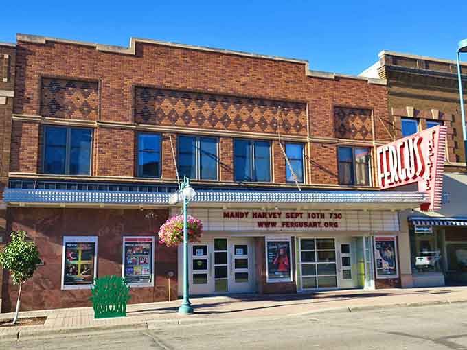 The Fergus Theatre marquee announcing Mandy Harvey proves this classic venue is very much alive, its diamond-patterned brick facade glowing warmly under a perfect Minnesota sky.