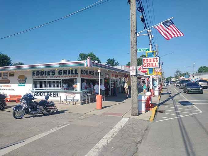 Eddie's Grill under a blazing summer sky, motorcycles parked out front, root beer signs glowing like a beautiful dream.