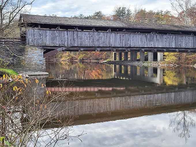 The whole bridge mirrored in the still Wallkill River below creates a reflection so perfect it looks like nature showing off.