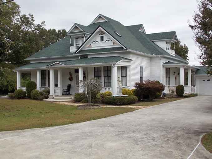 That wraparound porch and green gabled roof whisper stories of sweet tea and Sunday afternoons.