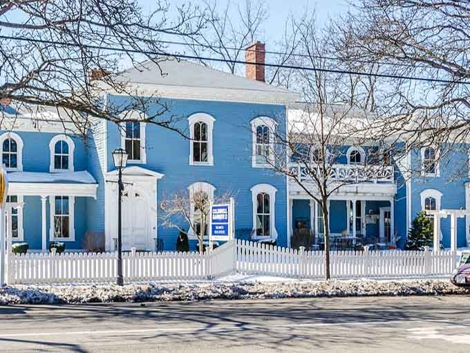 That cheerful blue facade with white trim pops against the snow like a perfectly wrapped present you want to unwrap.