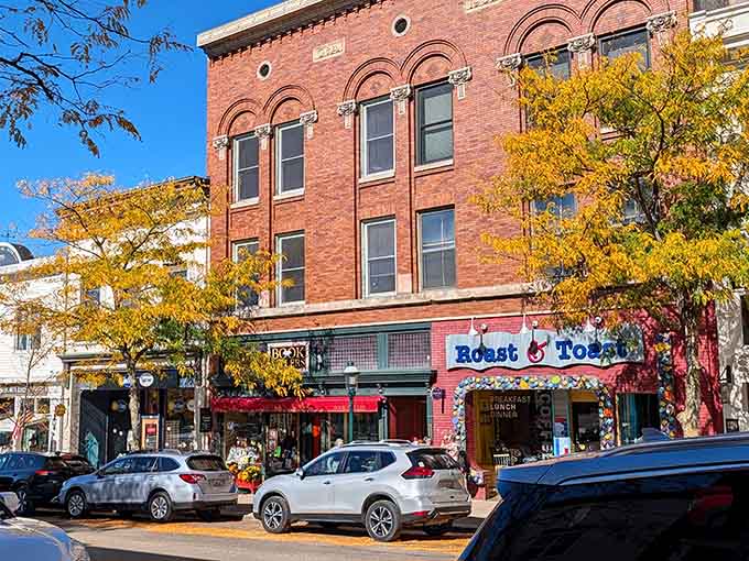 Roast & Toast's cheerful sign pops against Petoskey's warm autumn brick, beckoning you inside for coffee and conversation you won't soon forget.