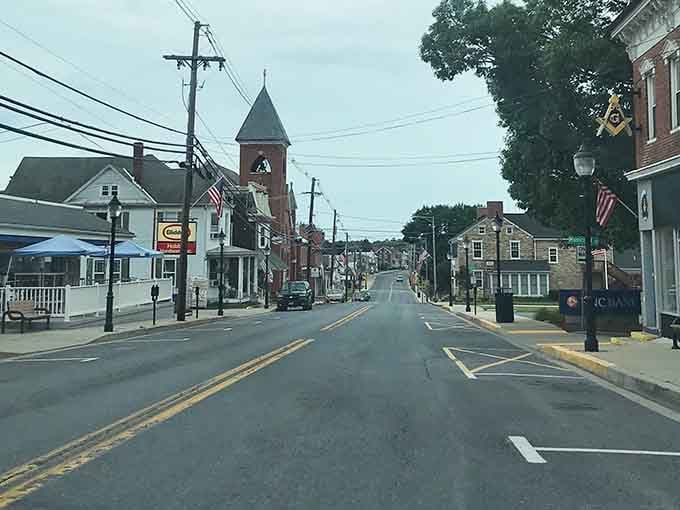 American flags lining a peaceful main street with a church steeple rising behind them — Thurmont is small-town Maryland with its best outfit on.