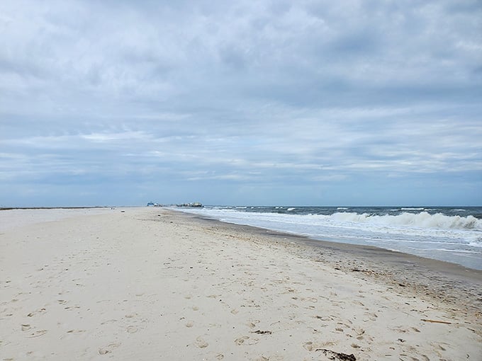 The beach curves gently under moody skies, proving that even cloudy days can't diminish this shoreline's natural charm.