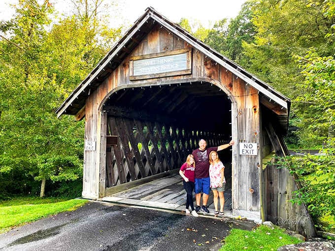 Three happy visitors pose beneath the "No Exit" sign, proving some places you simply never want to leave.