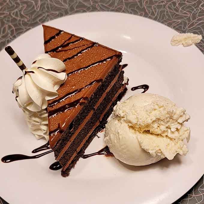 A towering slice of chocolate cake with ice cream that says dessert isn't optional. It never was.